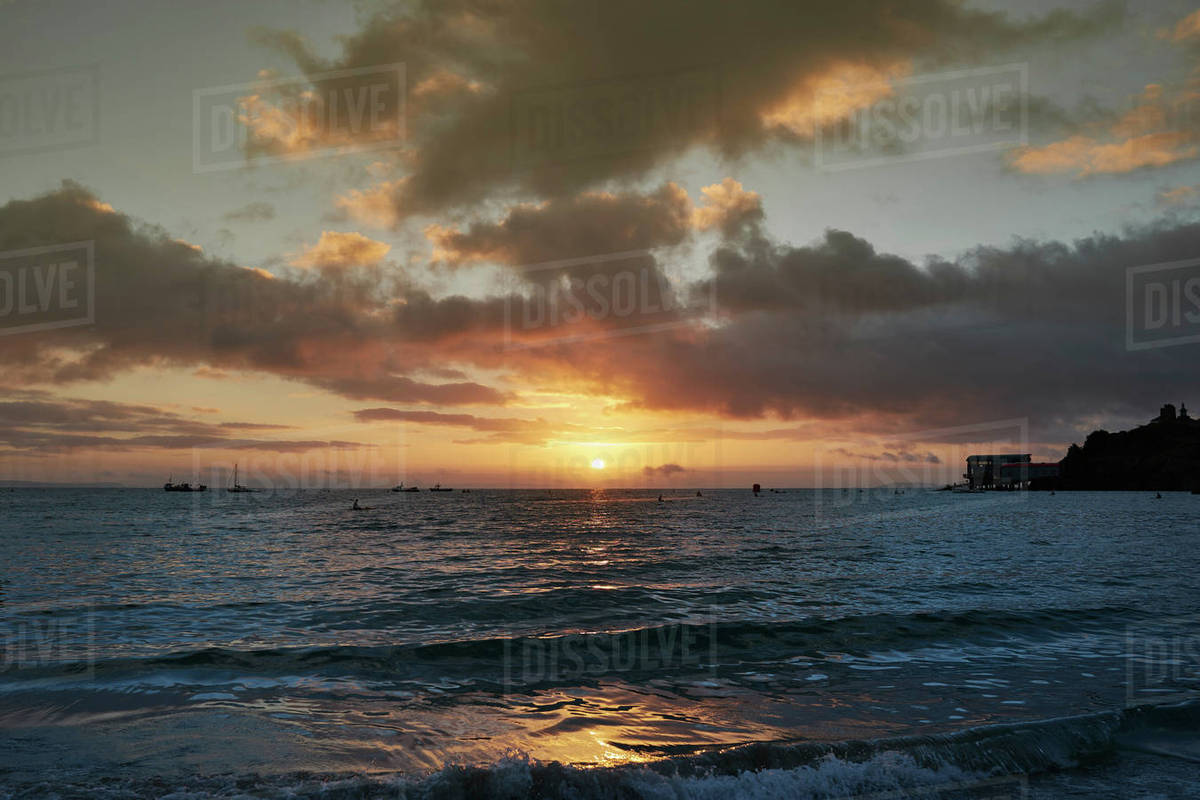 Silhouette of boats on sea at sunrise, Tenby, Pembrokeshire, Wales ...