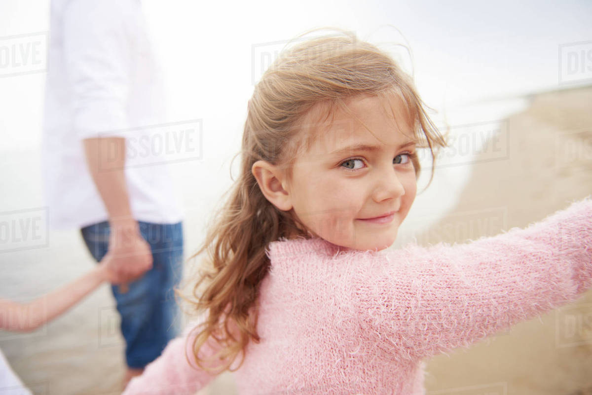 Family walking on beach, daughter looking over shoulders - Royalty-free ...