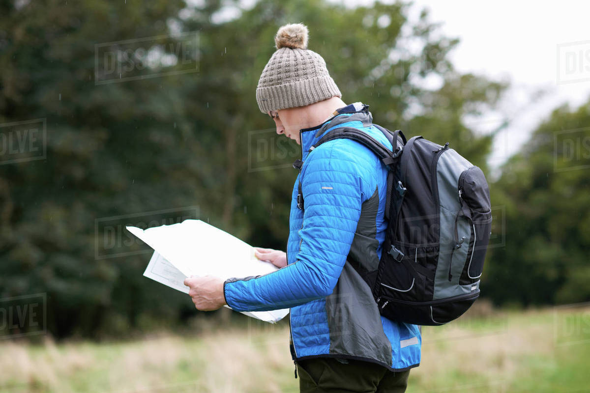 Hiker looking at paper map - Royalty-free Stock Photo | Dissolve