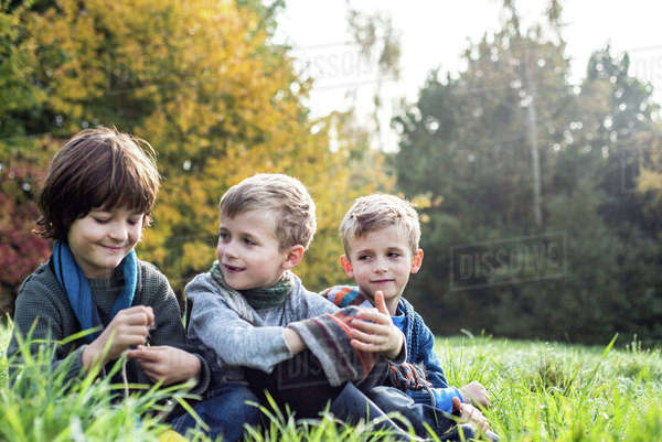 Three boys, sitting together in field, in autumn - Royalty-free Stock ...