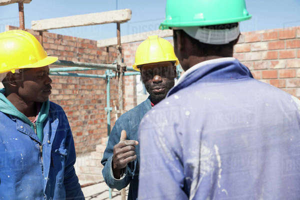 Builders talking on construction site - Royalty-free Stock Photo | Dissolve