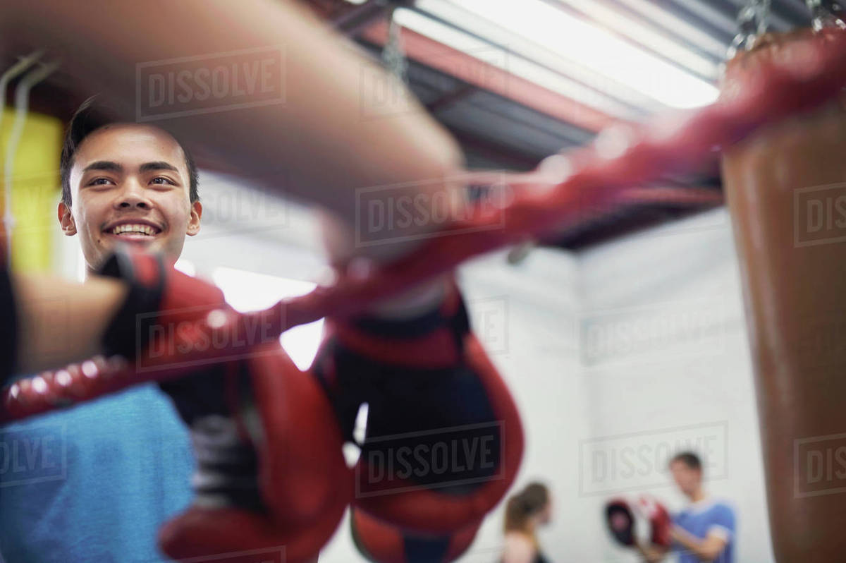 Arms of boxer leaning on boxing ring ropes - Stock Photo - Dissolve