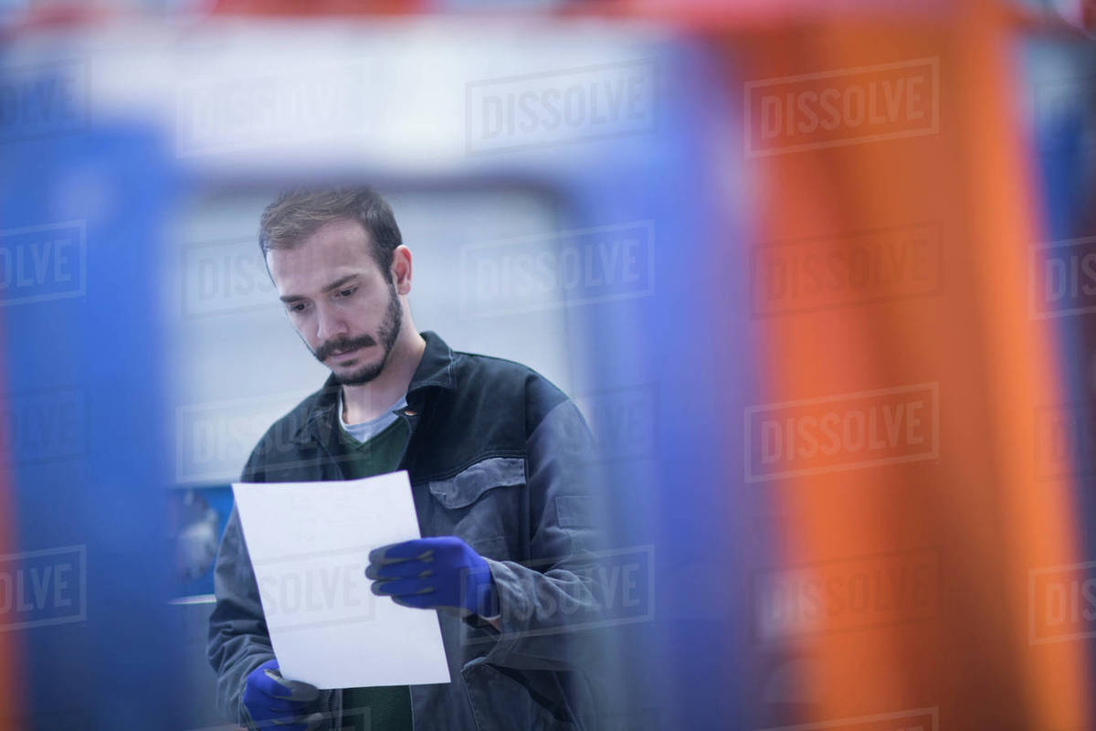 Engineer looking at paperwork - Stock Photo - Dissolve
