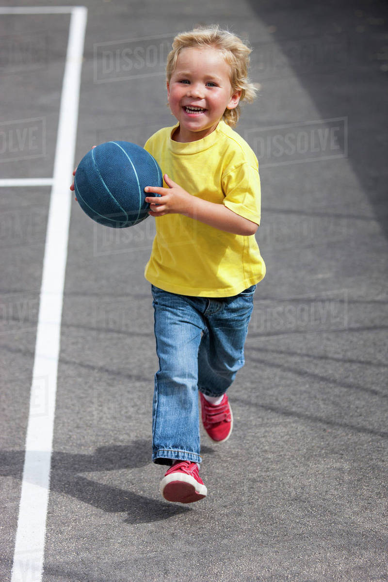 Preschool boy running with ball in preschool yard - Royalty-free Stock ...