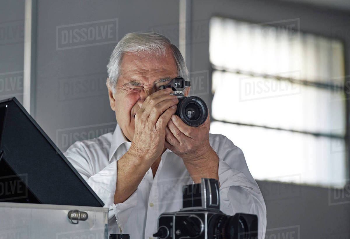 Senior man looking through camera - Royalty-free Stock Photo | Dissolve