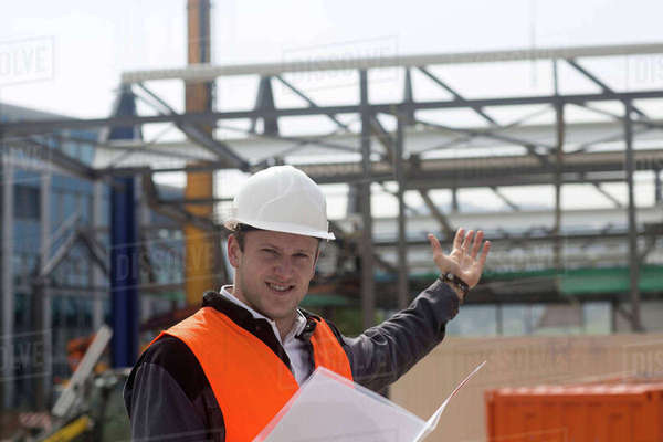 Portrait of young male civil engineer showing construction frame on ...