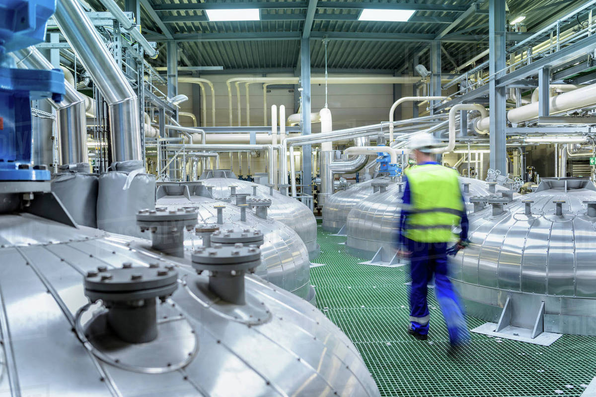 Worker with process machinery in oil blending factory - Stock Photo ...