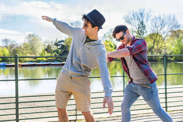Young man pushing friend on skateboard in Battersea Park - Stock Photo ...
