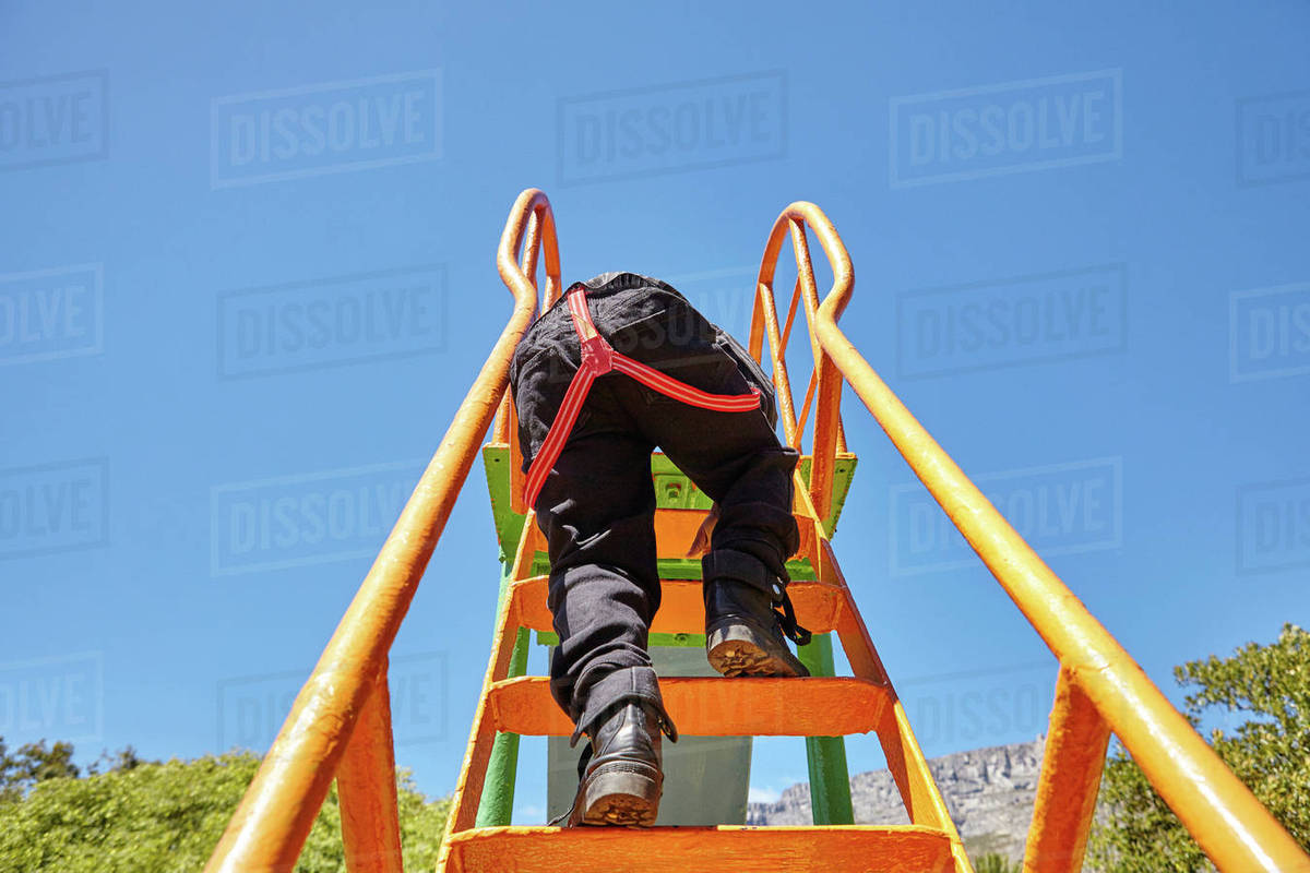 Boy climbing up slide in playground - Royalty-free Stock Photo | Dissolve