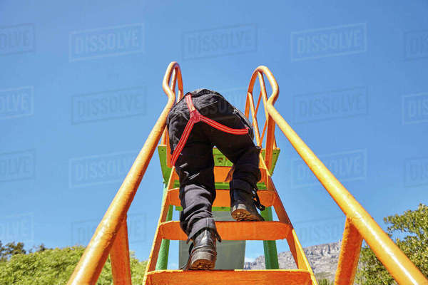 Boy climbing up slide in playground - Royalty-free Stock Photo | Dissolve
