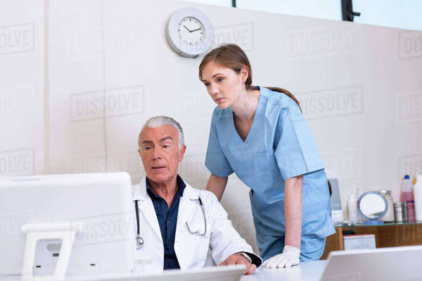 Doctors looking at computer - Royalty-free Stock Photo | Dissolve