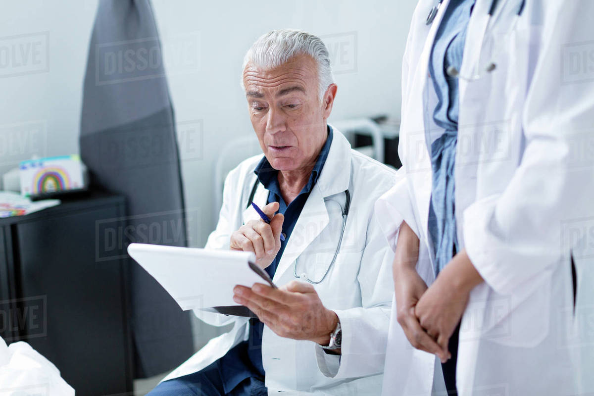 Doctor looking at medical chart - Royalty-free Stock Photo | Dissolve
