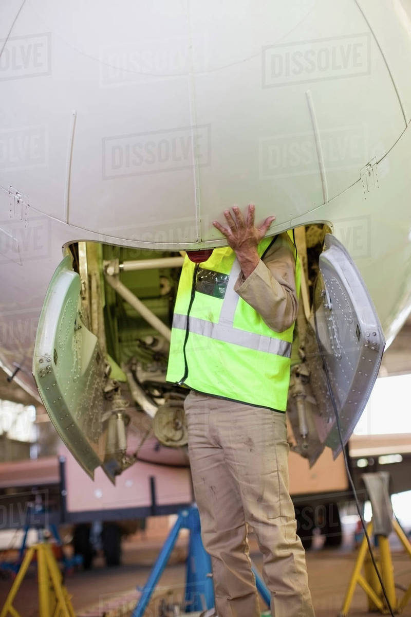Aircraft worker checking airplane - Royalty-free Stock Photo | Dissolve