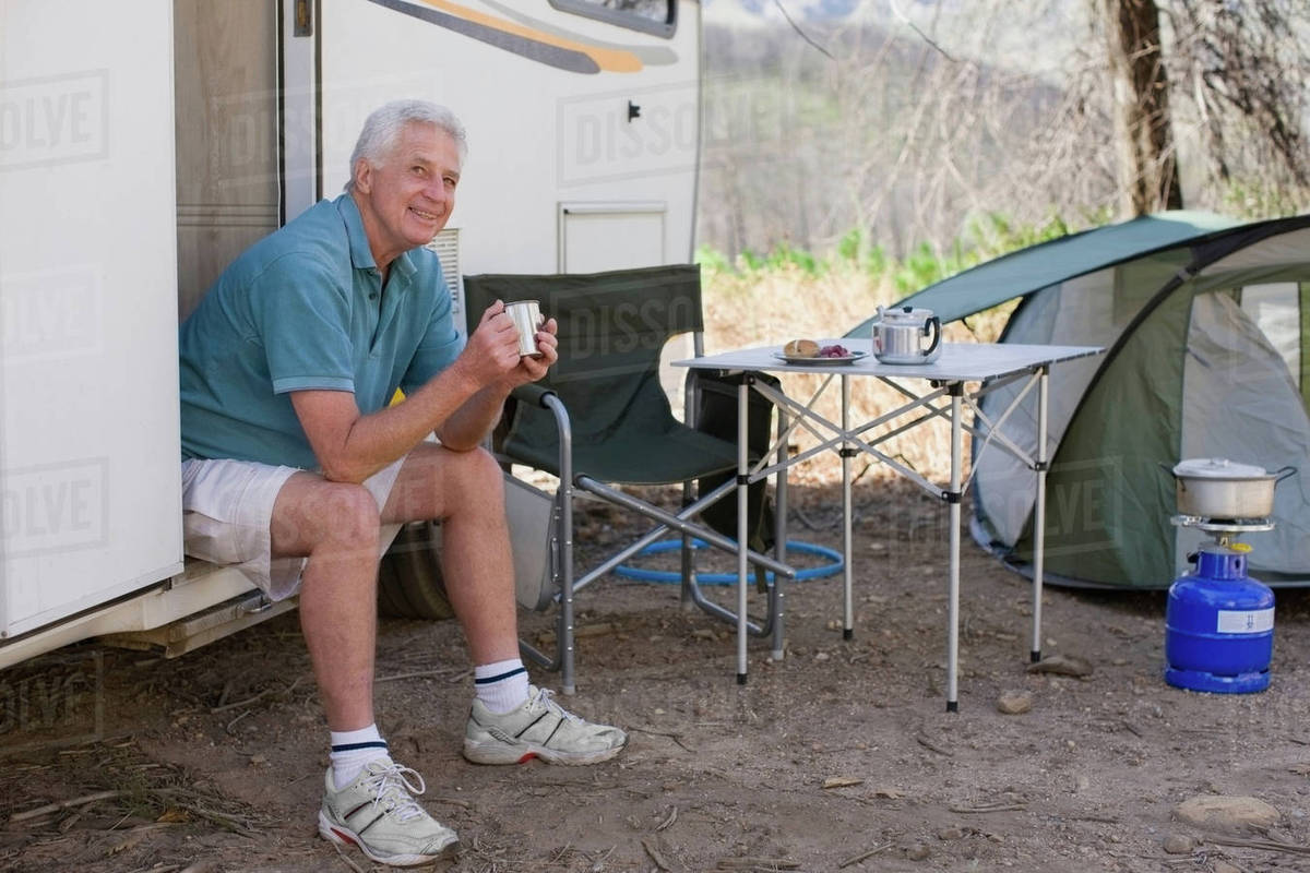 Older man camping with RV - Stock Photo - Dissolve