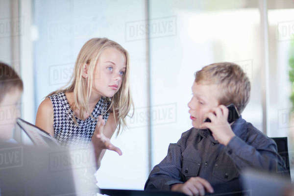 Children playing business people at desk - Stock Photo - Dissolve