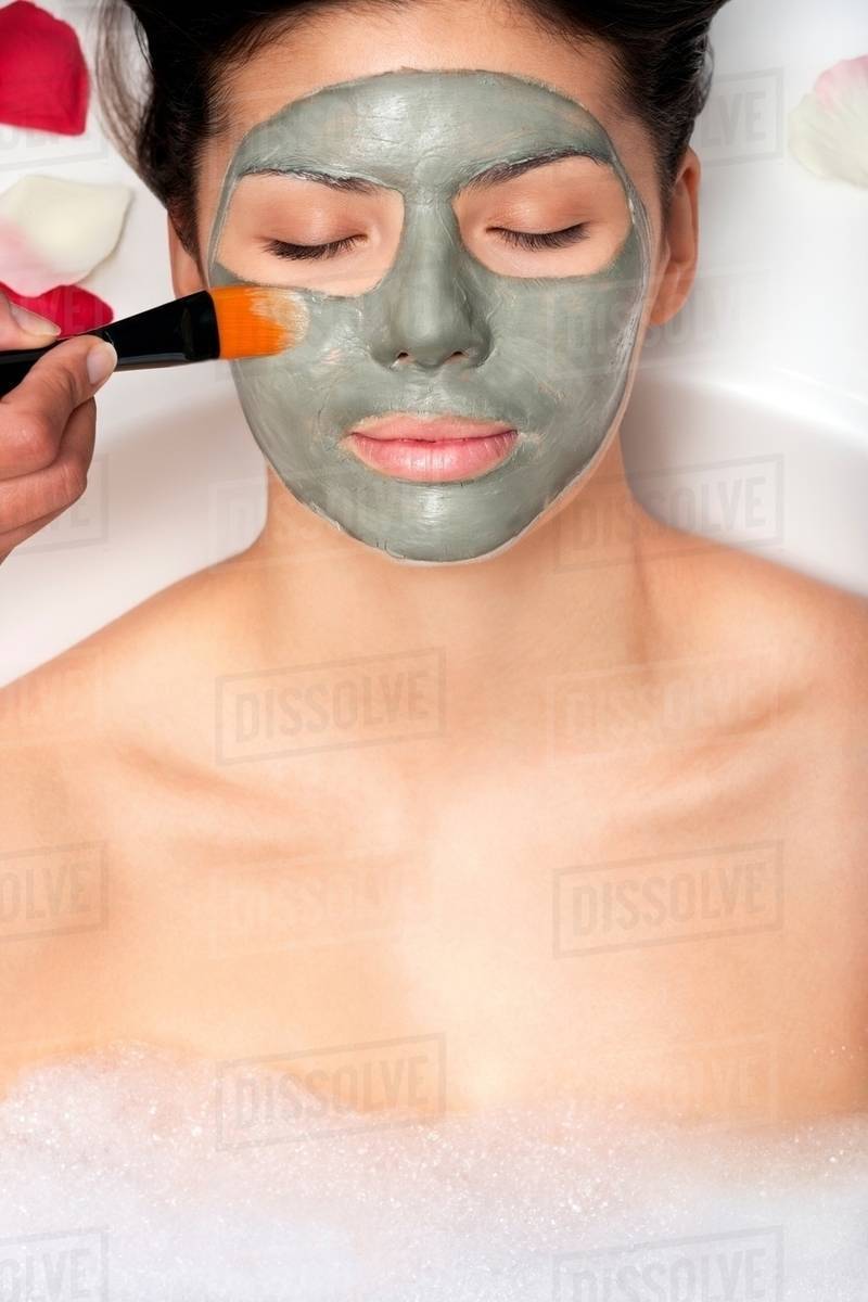 Woman having skin mask applied in bath - Stock Photo - Dissolve
