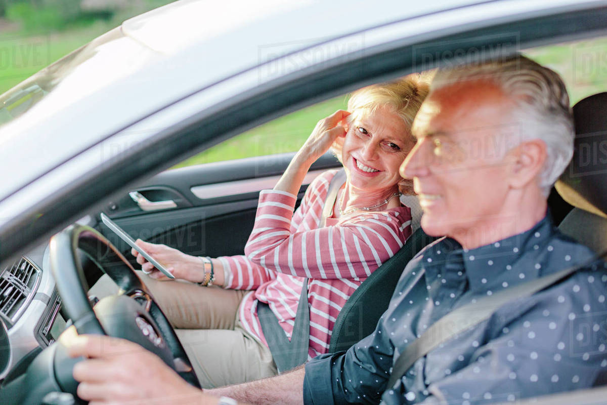 Happy tourist couple driving car - Royalty-free Stock Photo | Dissolve