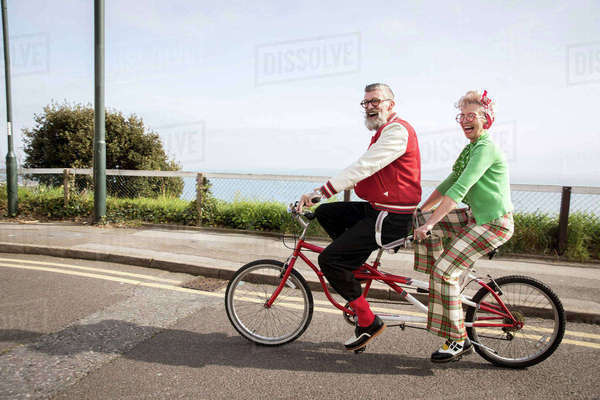 Quirky couple sightseeing on tandem bicycle, Bournemouth, England ...