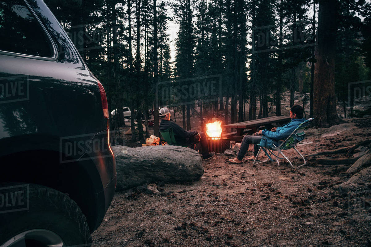 Friends camping in forest by campfire, Mammoth Lake, California, USA ...