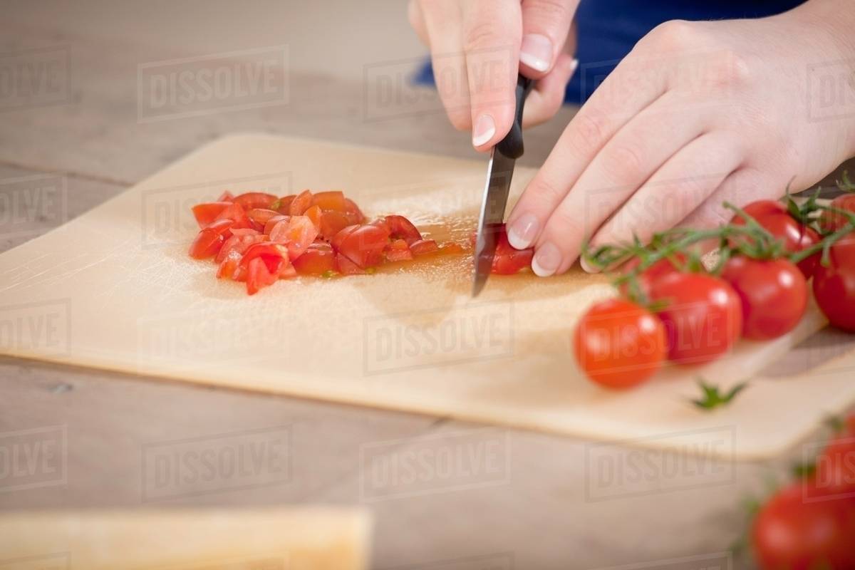 Close up of woman chopping tomatoes - Stock Photo - Dissolve
