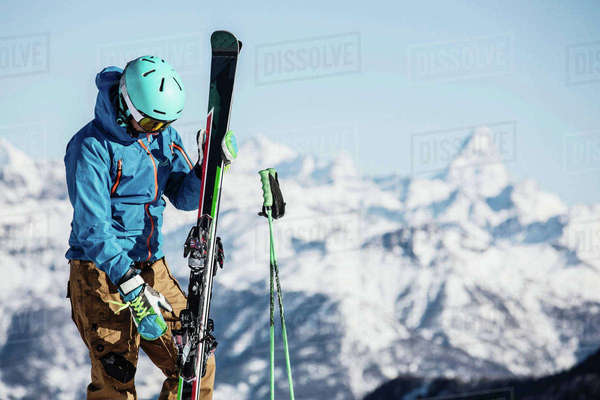 Skier preparing to put on skis - Stock Photo - Dissolve