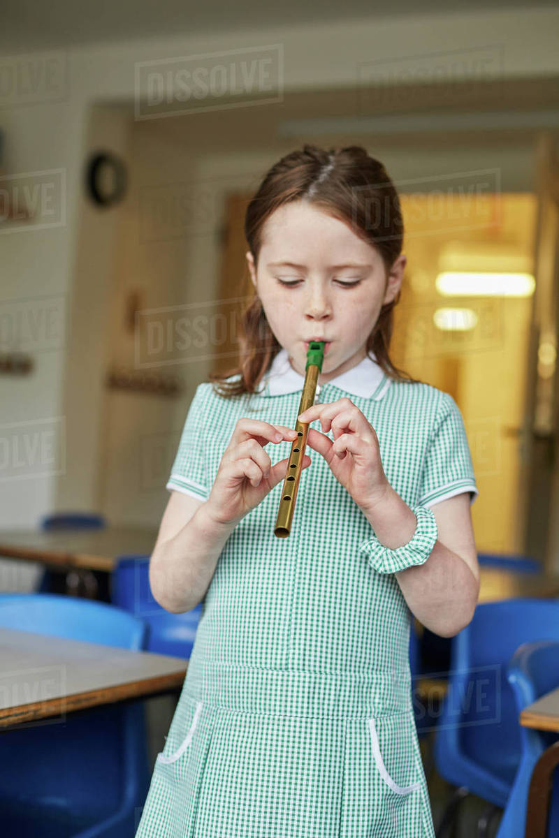Schoolgirl playing recorder in classroom at primary school - Royalty ...