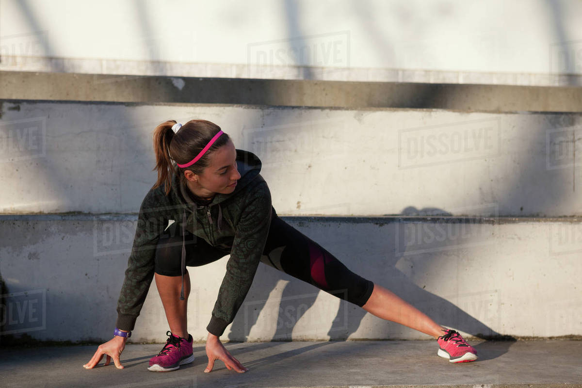 Young woman warming up, stretching legs - Royalty-free Stock Photo ...
