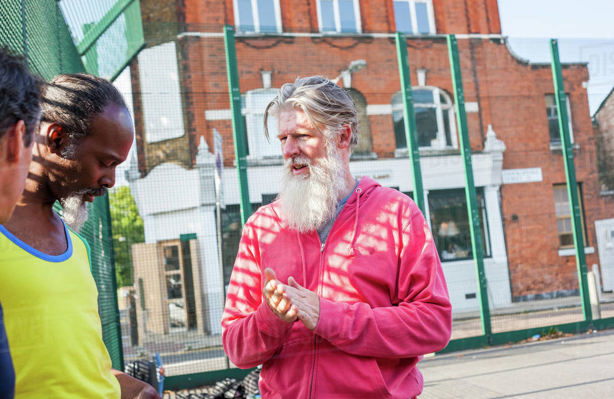 Three mature men outdoors, standing together, talking - Royalty-free ...