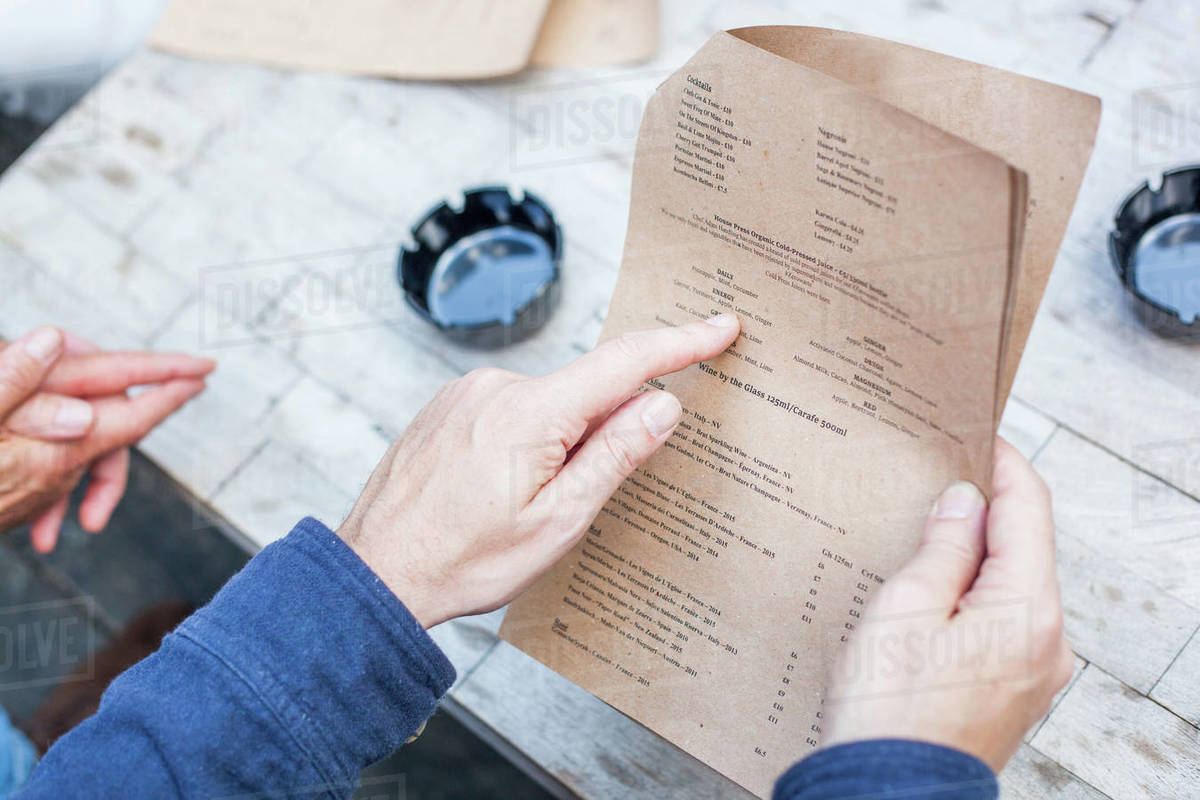 Man pointing at menu - Stock Photo - Dissolve