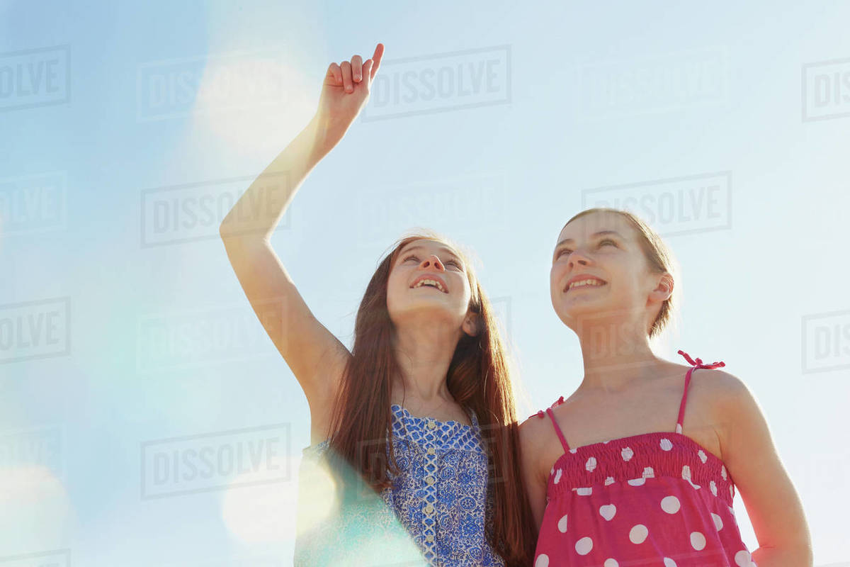 Best friends pointing up and looking up at sky - Royalty-free Stock ...