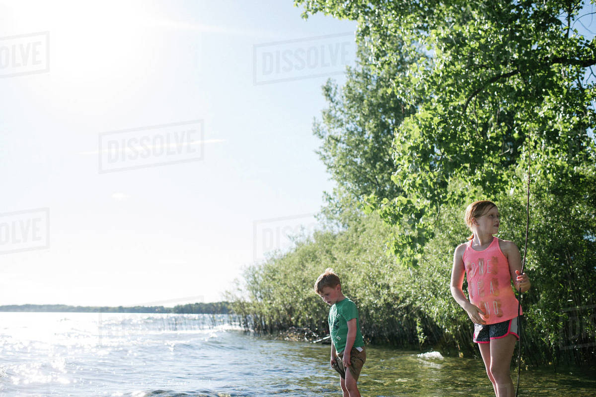 Siblings exploring shore with stick, Kingston, Canada - Royalty-free ...