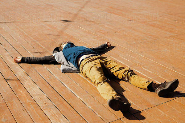 Man relaxing on wooden decking - Royalty-free Stock Photo | Dissolve