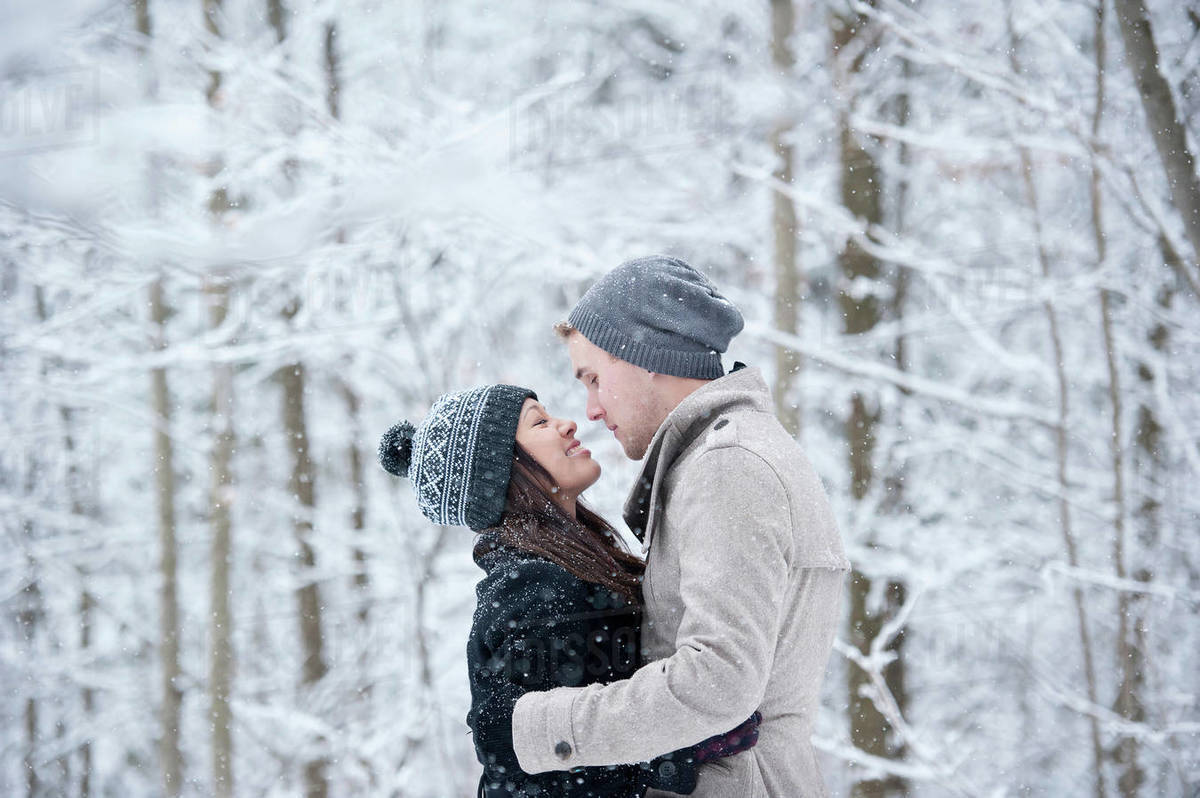Romantic young couple face to face in snowy forest, Ontario, Canada ...