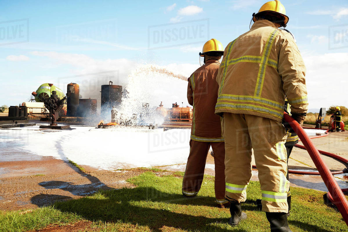 Firemen training, team of firemen spraying firefighting foam at ...
