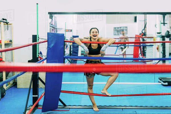 Female boxer leaning over boxing ring ropes - Stock Photo - Dissolve