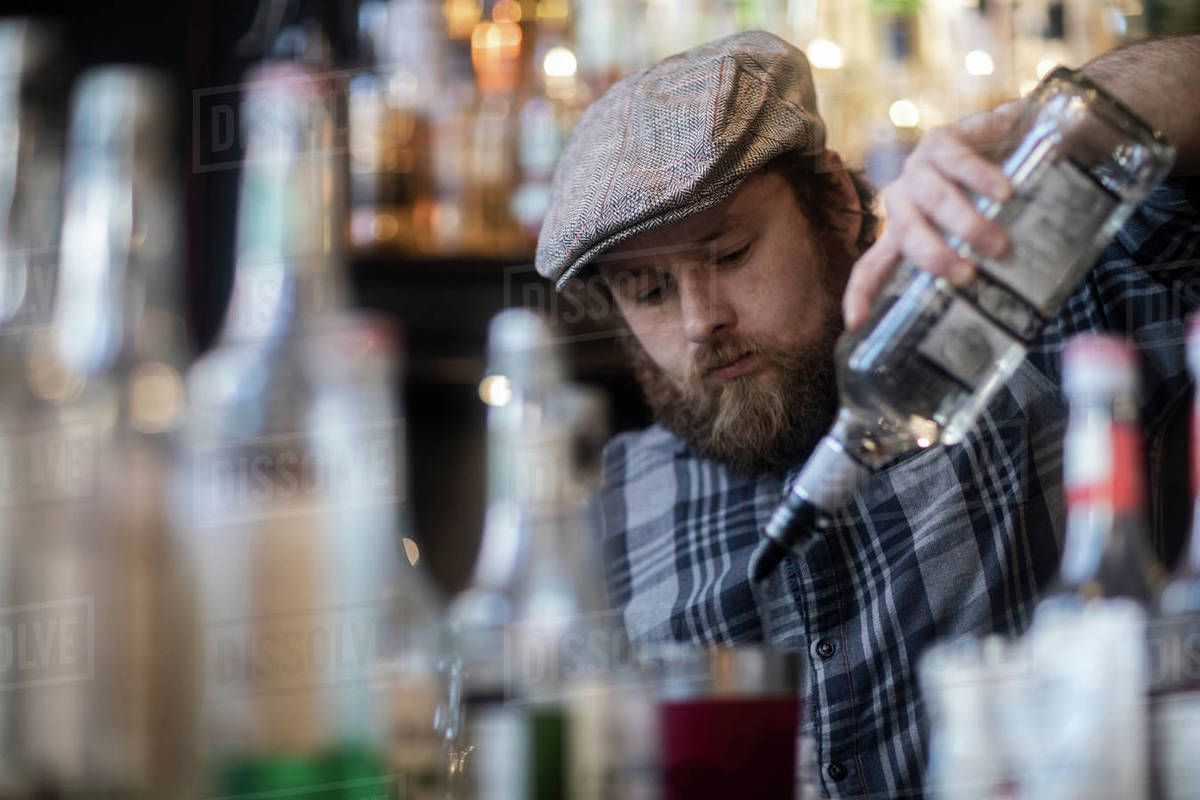 Barman pouring spirit bottle in traditional Irish public house ...