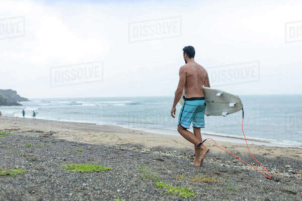 Surfer with surfboard on beach, Pagudpud, Ilocos Norte, Philippines ...