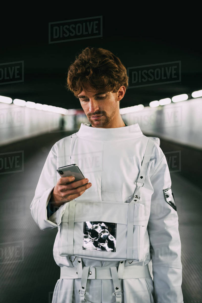 Astronaut using smartphone on covered bridge - Royalty-free Stock Photo ...