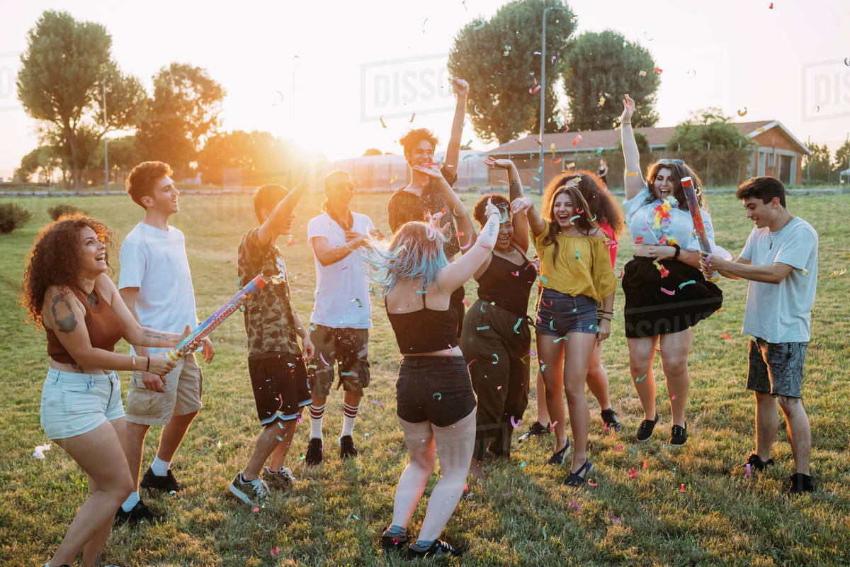 Group of friends playing with confetti in park - Royalty-free Stock ...