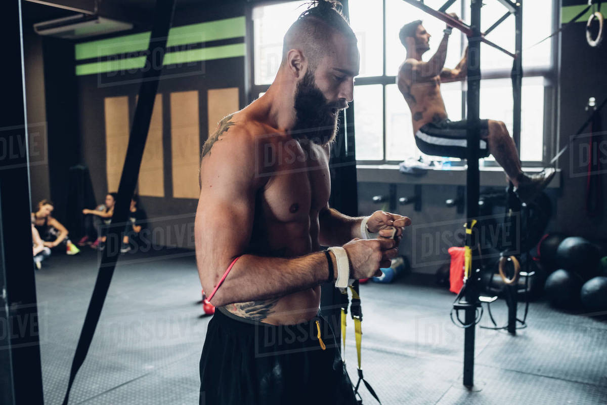 Young men training in gym, on exercise bar - Stock Photo - Dissolve
