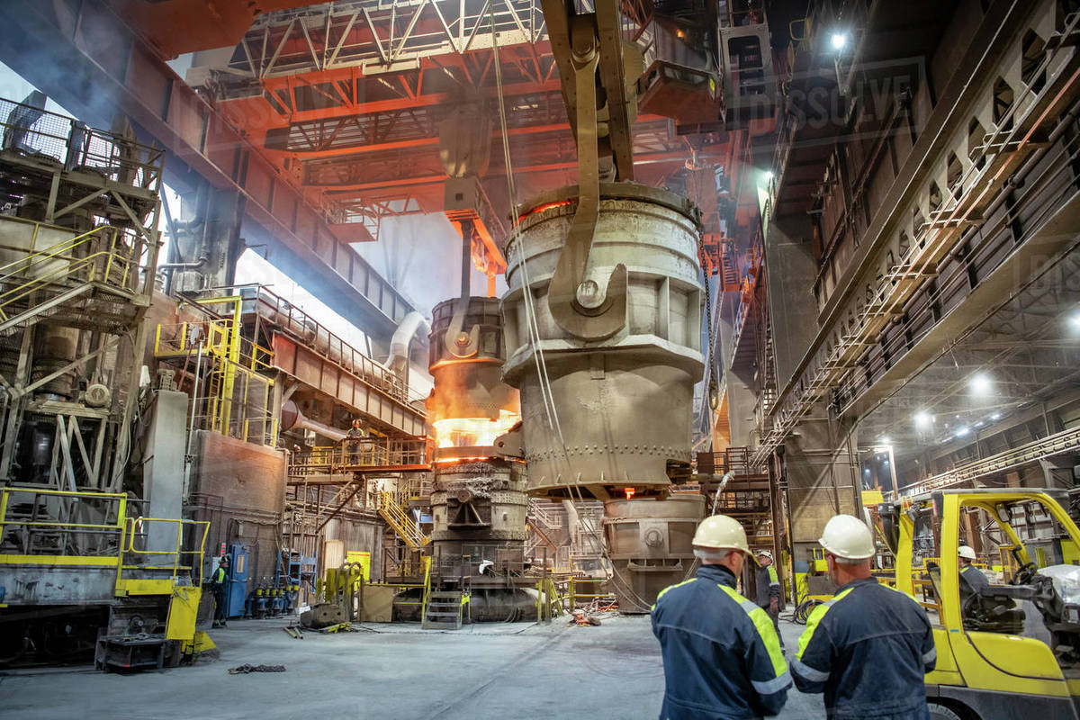 Steelworkers looking on during steel pour in steelworks - Stock Photo ...