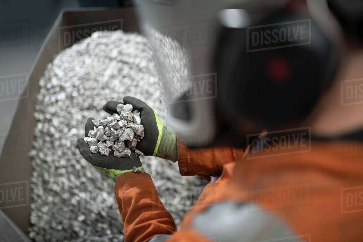 Close up of worker holding titanium sample in crushing plant in ...