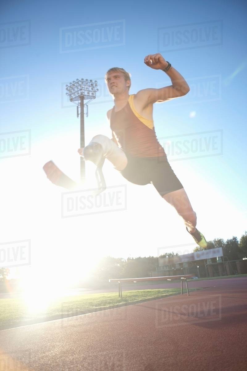 Sprinter mid-jump - Stock Photo - Dissolve