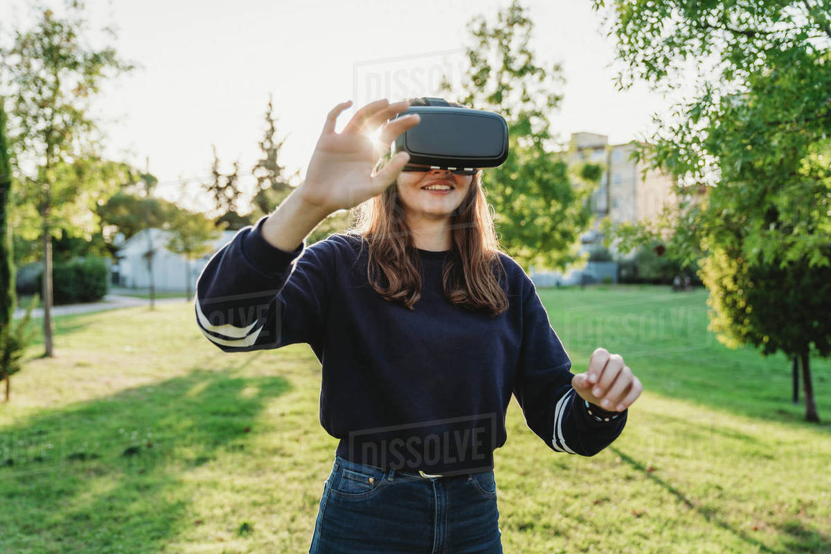 Young woman looking through VR headset in park - Royalty-free Stock ...