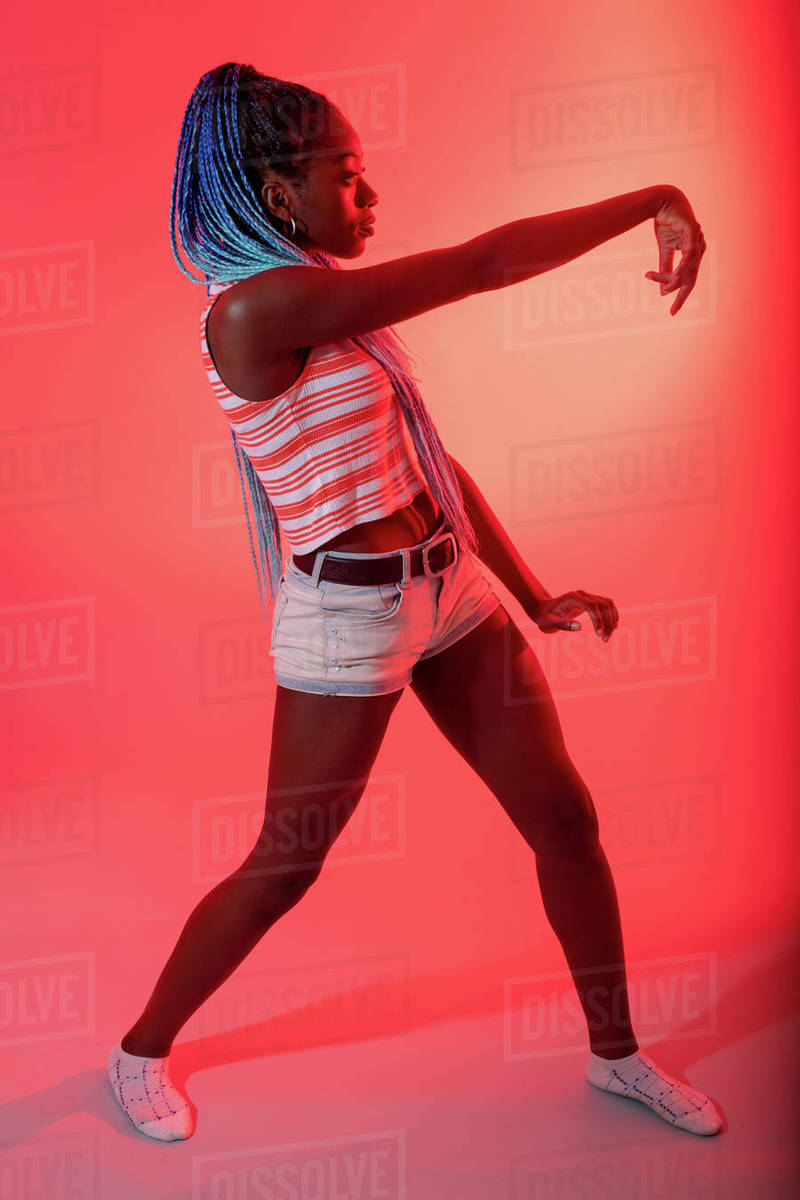 Woman with arm reaching out against red background - Stock Photo - Dissolve