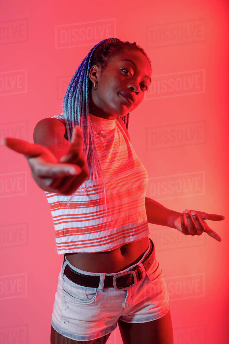 Woman with arm reaching out against red background - Stock Photo - Dissolve