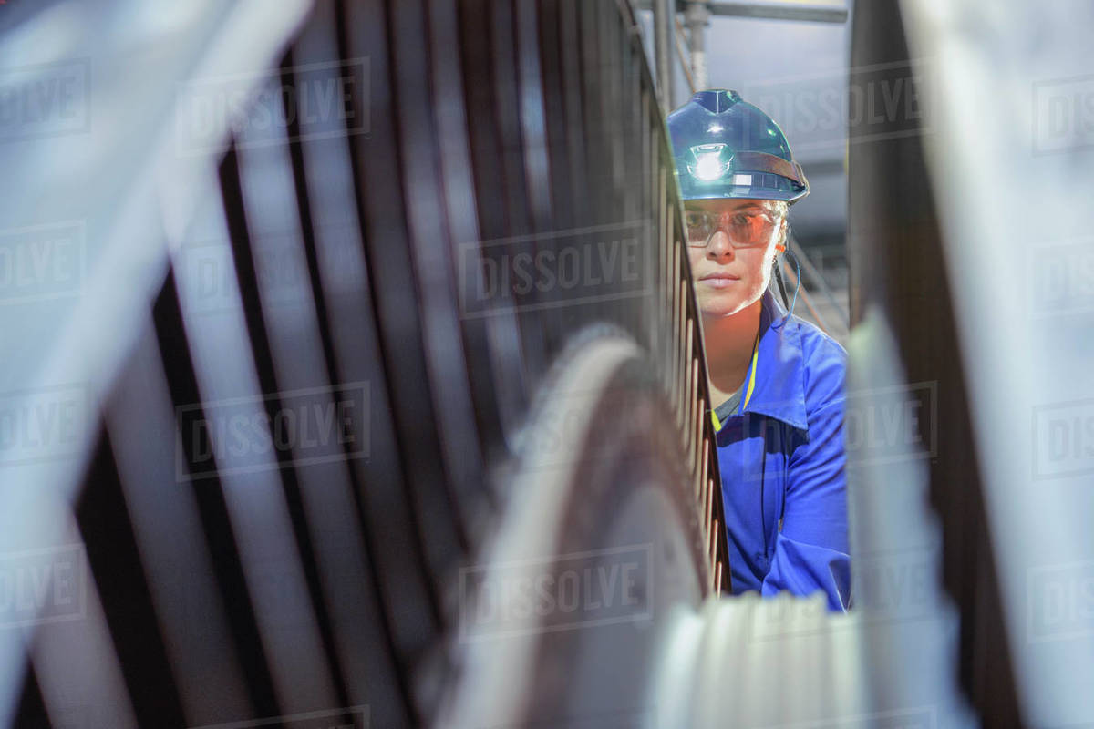 Female engineer inspecting a turbine in a nuclear power station ...