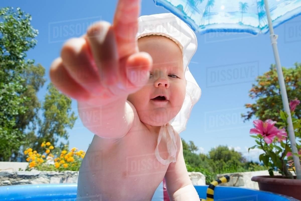 Baby girl in swimming pool pointing finger - Royalty-free Stock Photo ...
