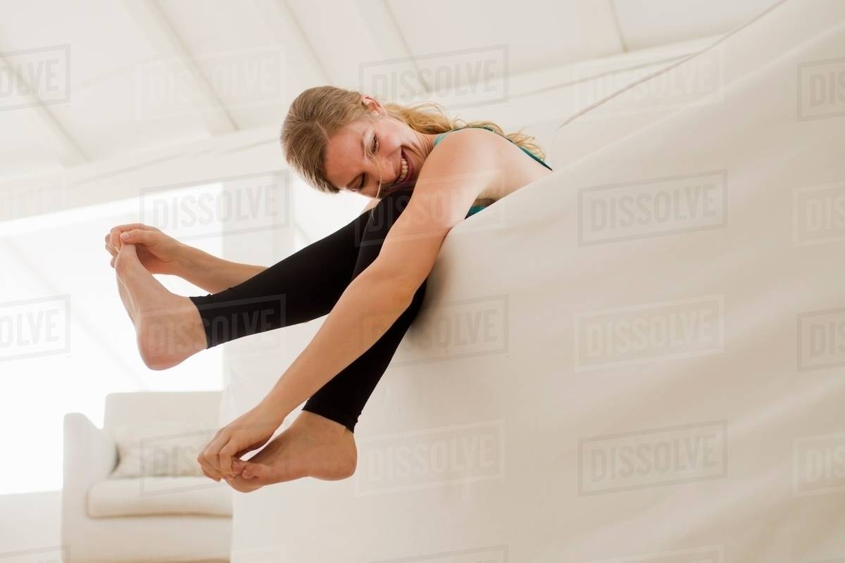 Woman dangling legs over sofa - Royalty-free Stock Photo | Dissolve