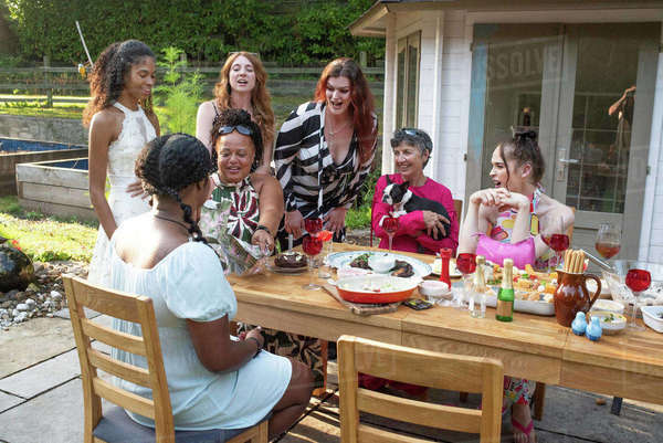 A mixed gathering of women laughing and having fun at a summer garden ...